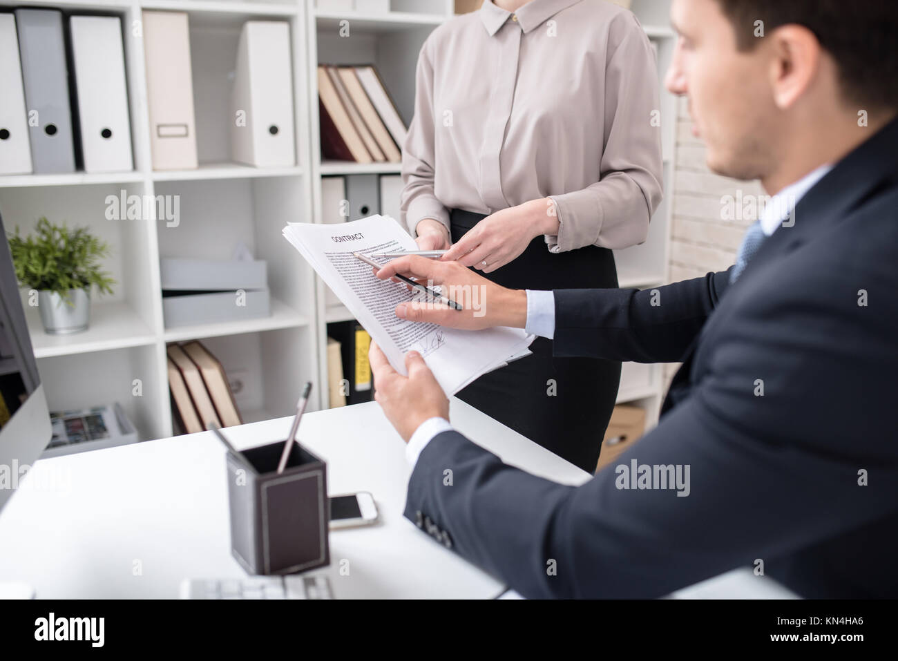 Back view portrait of young businessman reading contract held by his ...