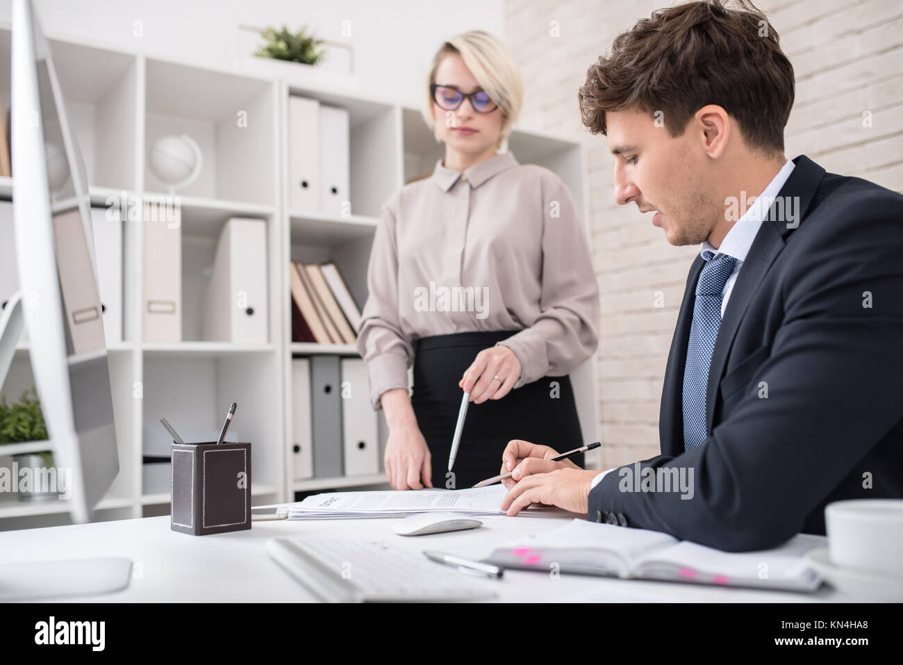 Side view portrait of handsome business executive signing documents ...