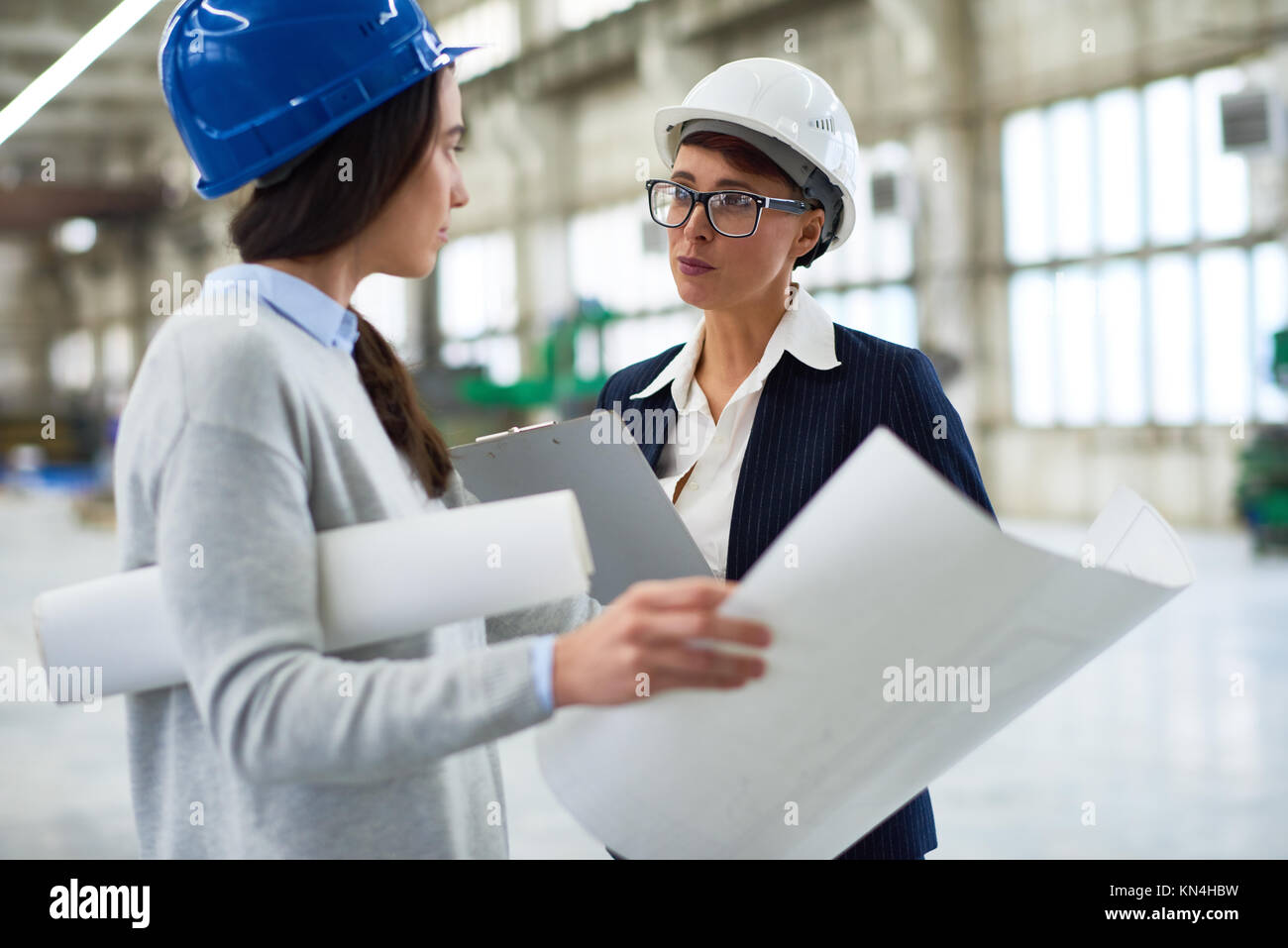 Studying Blueprint with Superior Stock Photo - Alamy