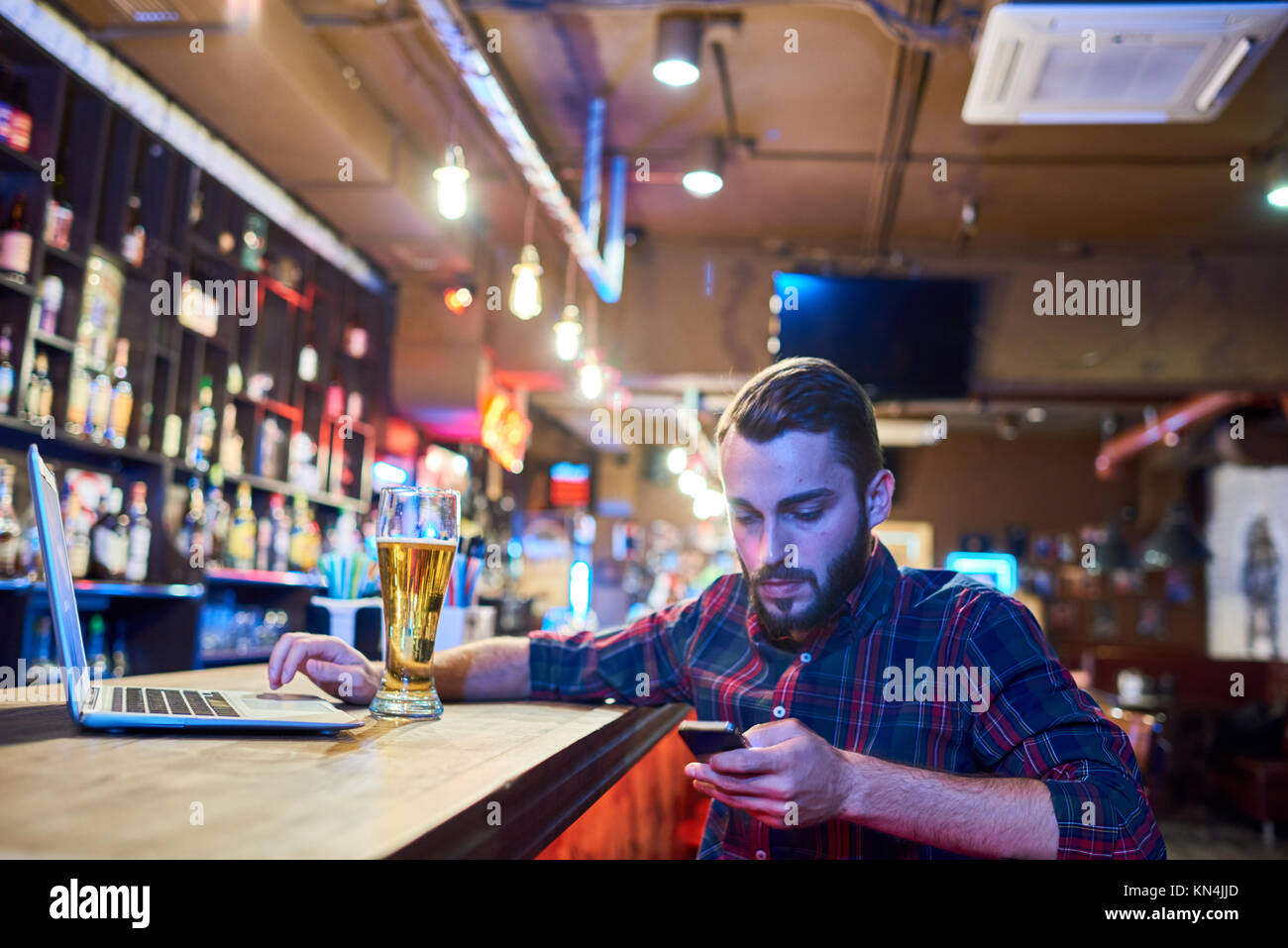 Man Using Smartphone in Pub Stock Photo - Alamy