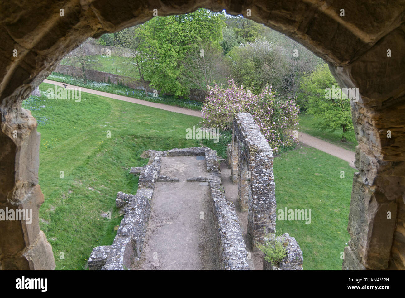 View of the remains of Battle Abbey through an ancient stone window ...