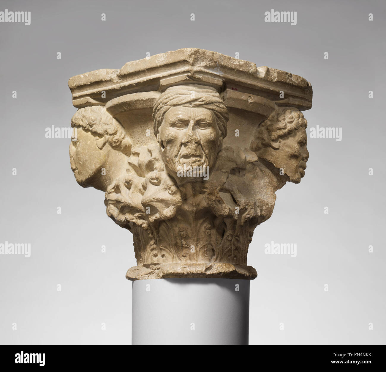This capital features four heads, likely representing figures of ...