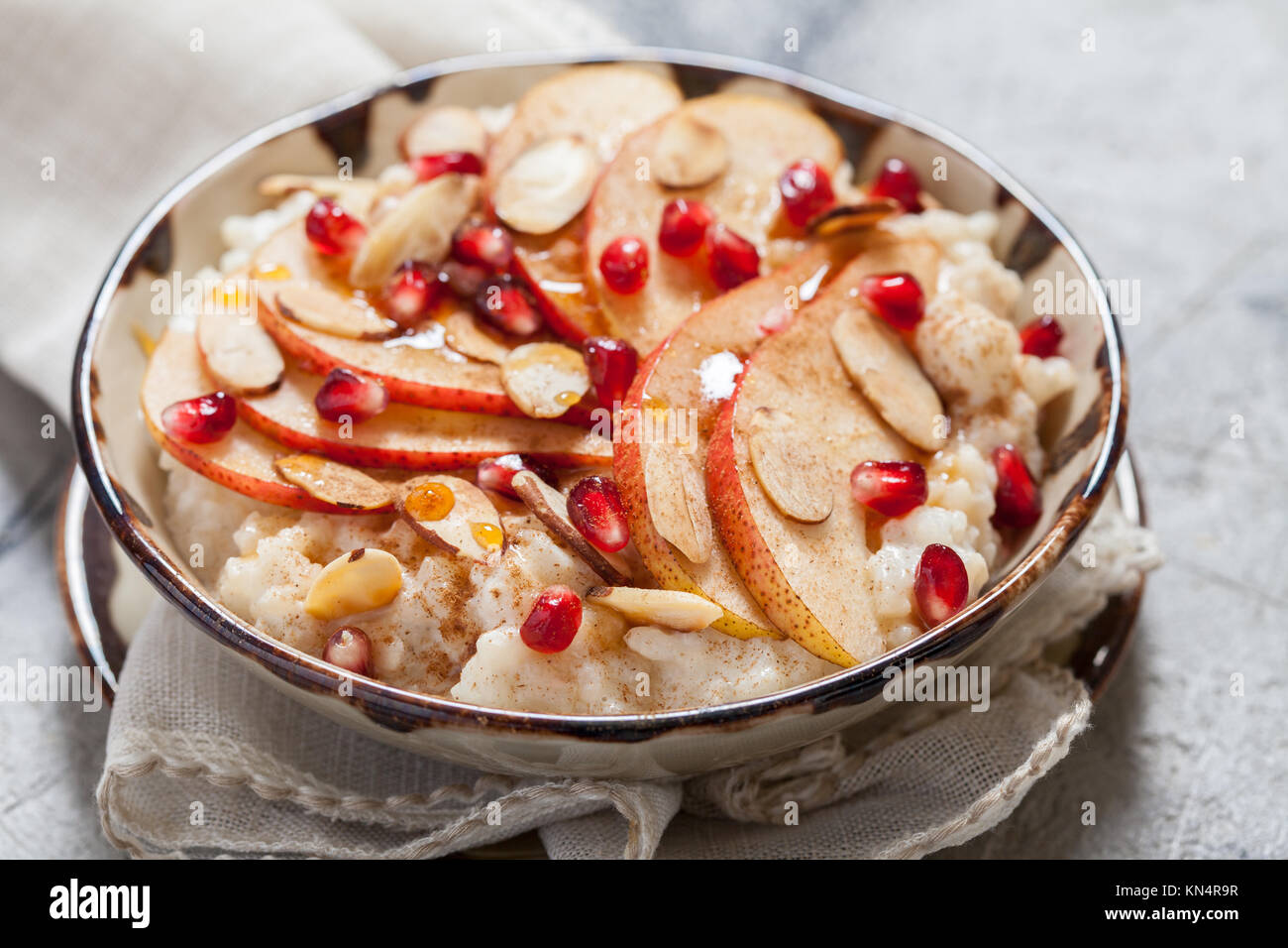 Coconut rice with pomegranate, pear and almond slices Stock Photo - Alamy