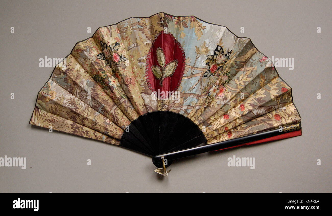 This fan, crafted from delicate materials, showcases intricate design ...