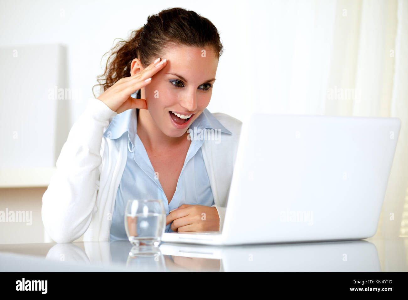 Excited and surprised young woman reading on laptop screen at home ...