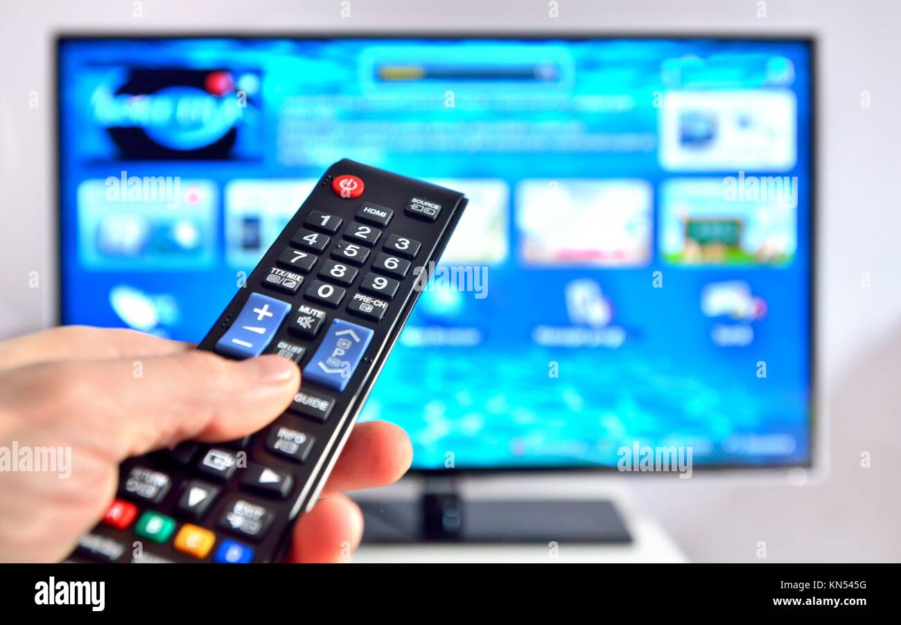 Smart tv and hand pressing remote control Stock Photo - Alamy