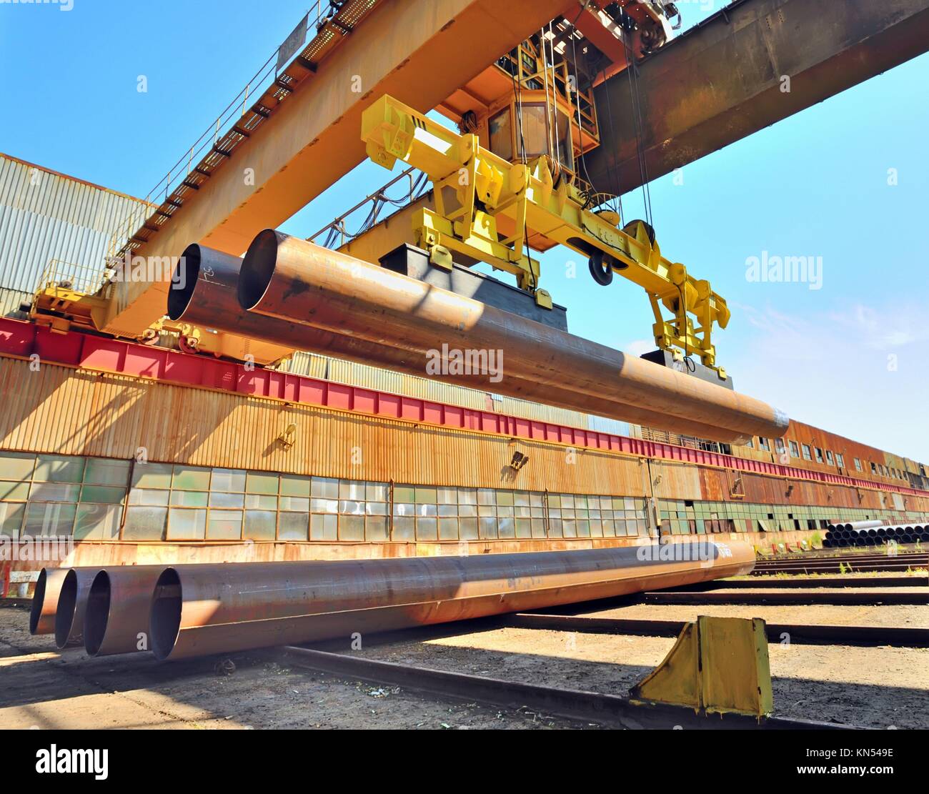 Loading pipes With Bridge Crane on industrial place Stock Photo - Alamy