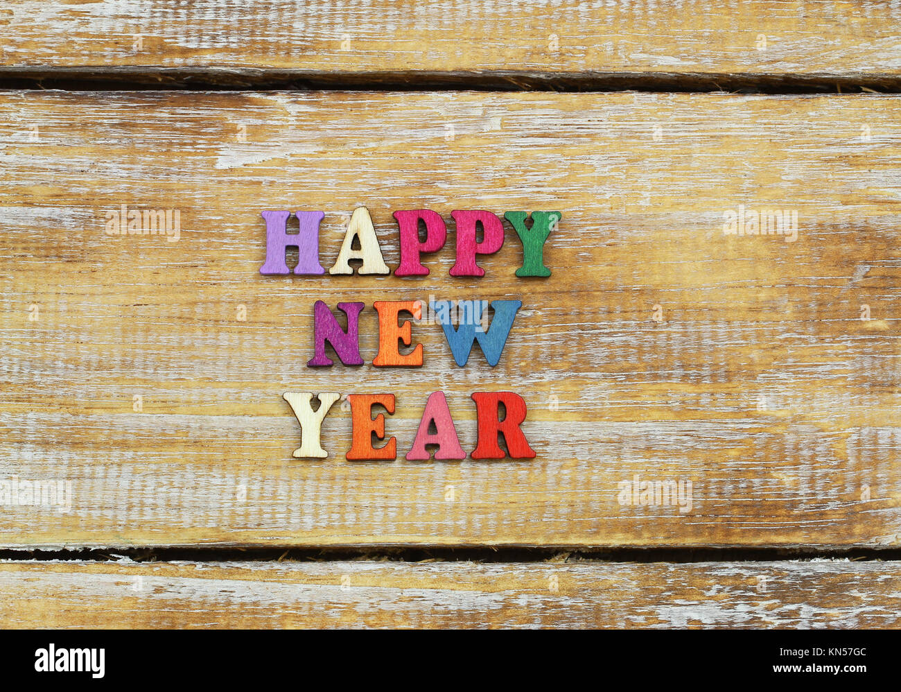 Happy New Year written with colorful wooden letters on rustic surface ...