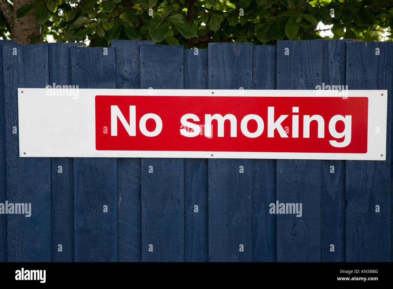 Red No Smoking Sign on Blue Fence Stock Photo - Alamy