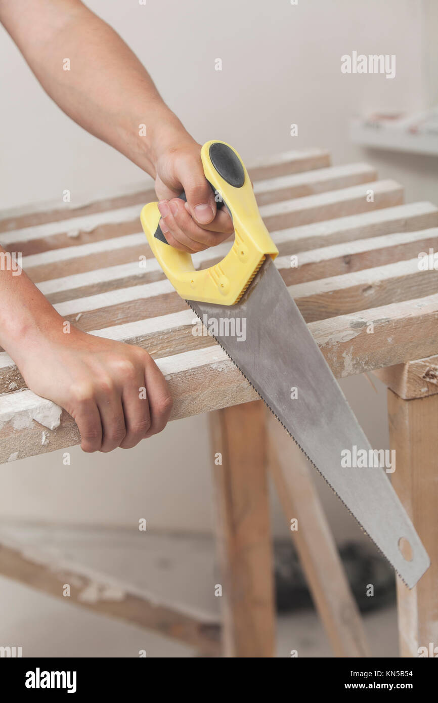 Sawing by the hand saw of wooden whetstone Stock Photo - Alamy