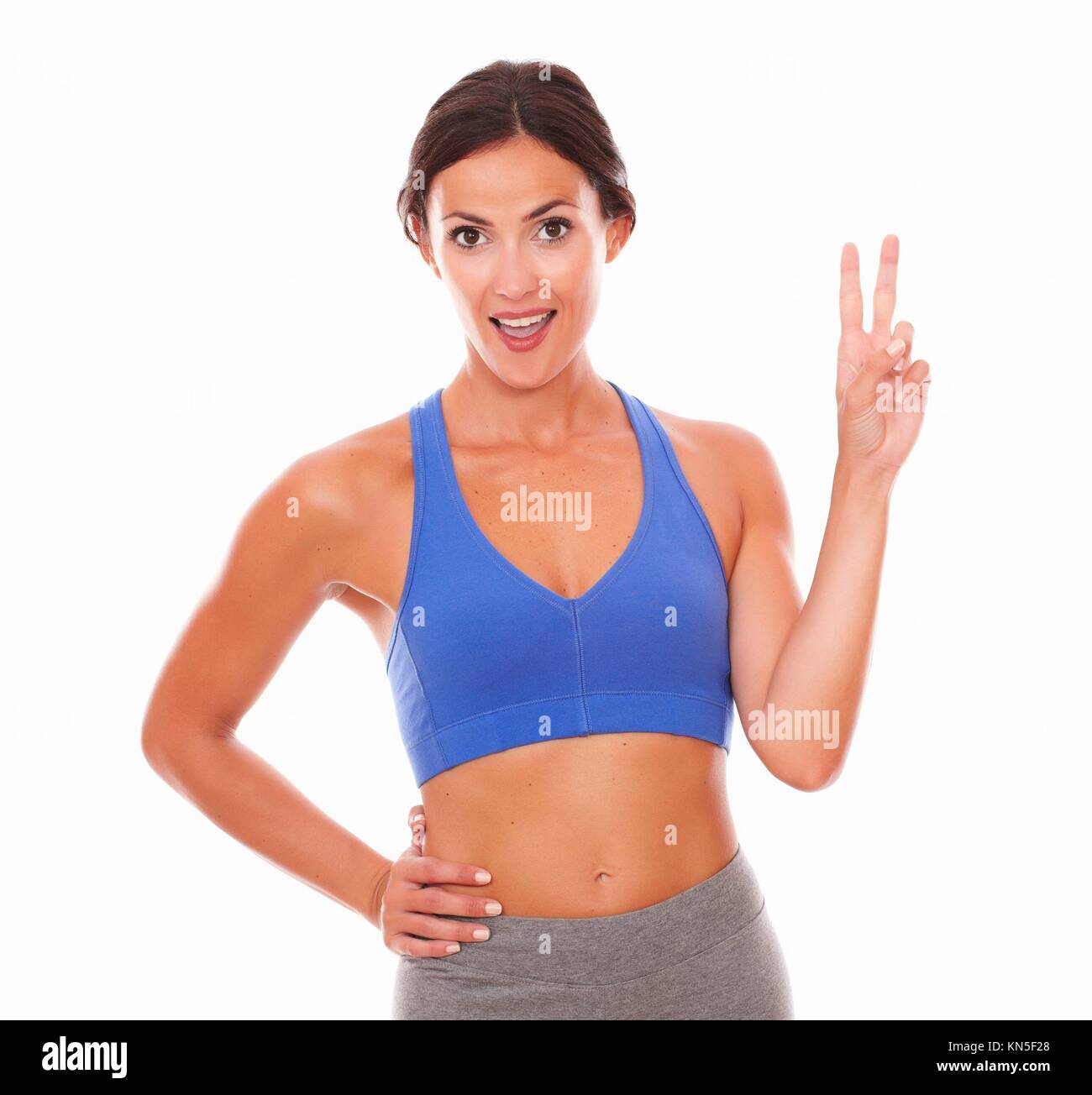 Fit woman looking positively cheerful against white background Stock ...