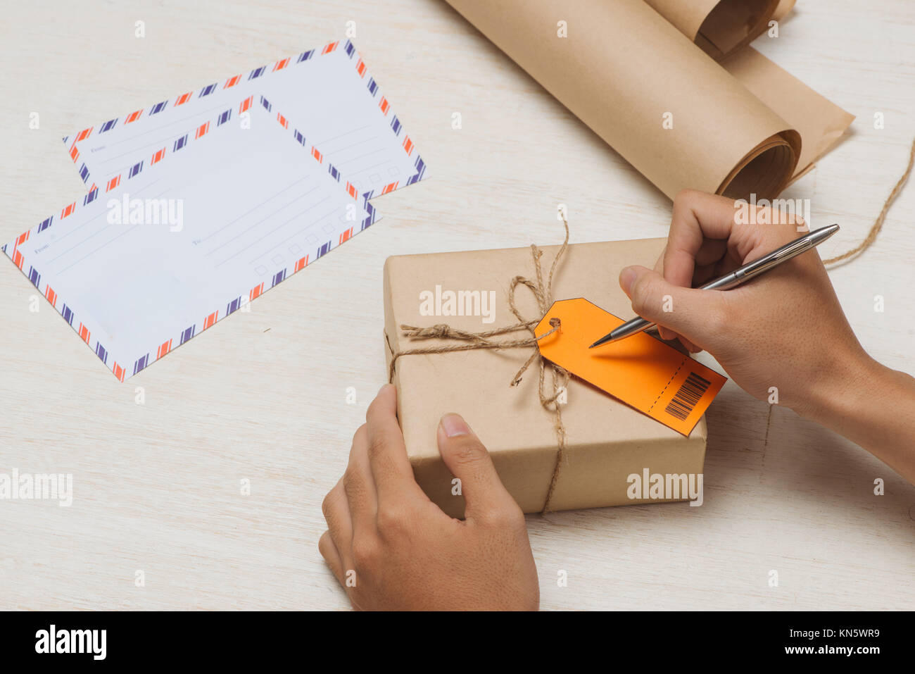 Male hand writing on luggage tag on brown paper parcel Stock Photo - Alamy