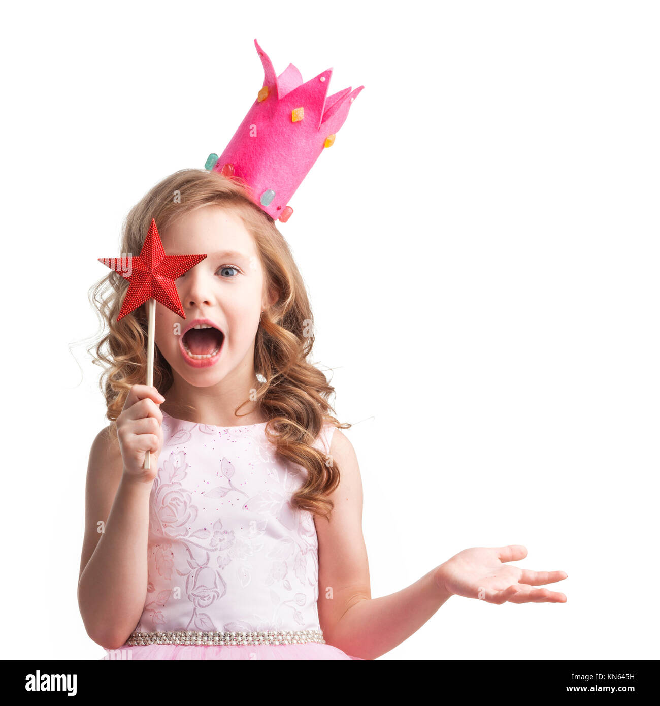Little fairy girl in pink dress and crown with magic wand putting spell ...