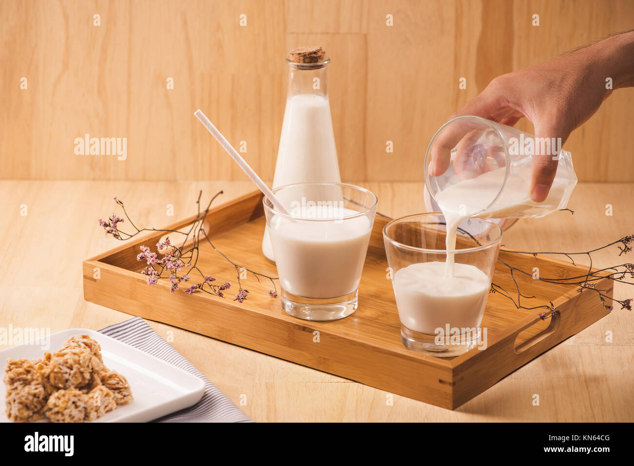 milk pour from bottle, almond candies on wooden background Stock Photo ...