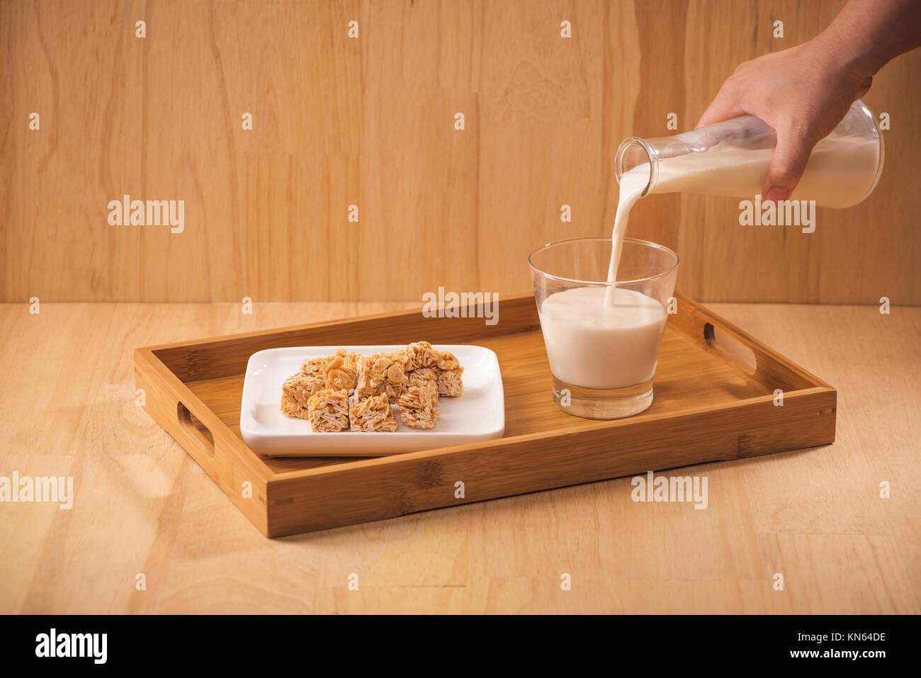 milk pour from bottle, almond candies on wooden background Stock Photo ...