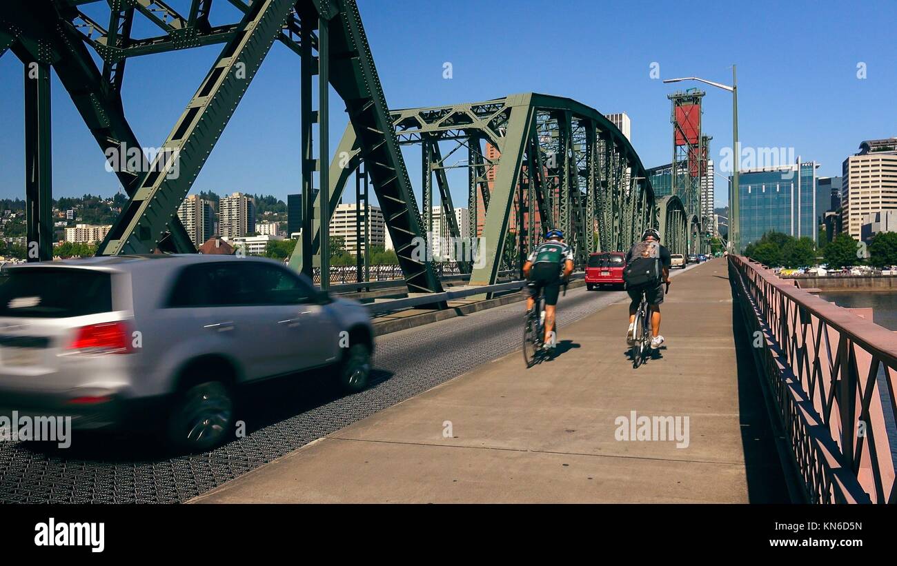 Cyclists and automobiles cross the Hawthorne Bridge heading into ...