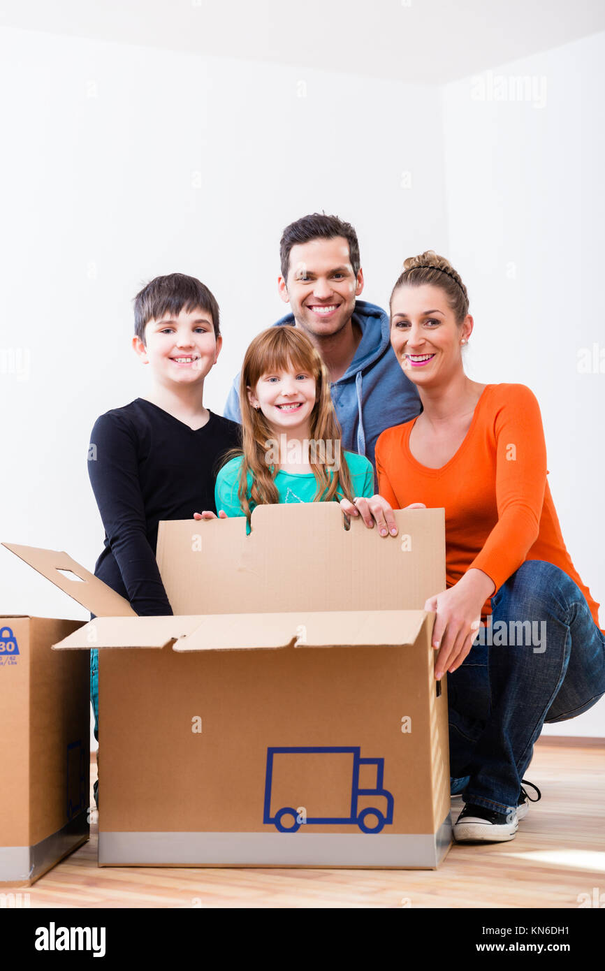 Family unpacking moving boxes in new home Stock Photo - Alamy