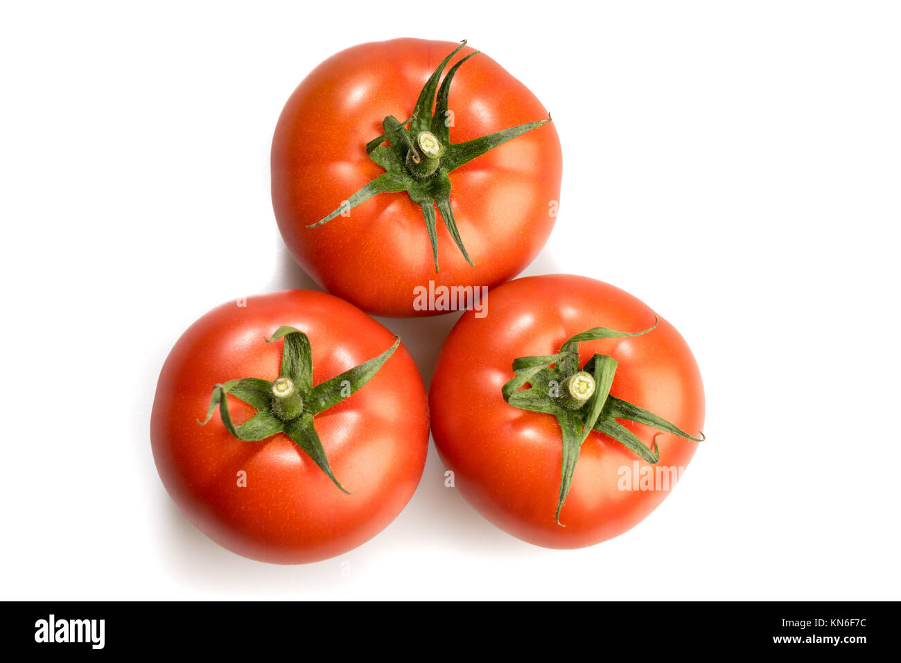 three realistic looking fresh red tomatoes lying in a triangle isolated ...