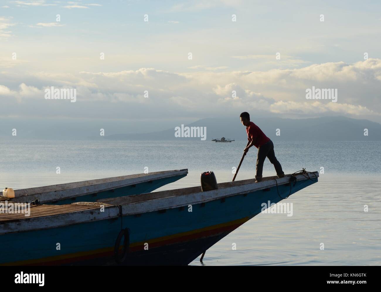 Traditional boat driver preparing for docking in Timampu harbor in ...