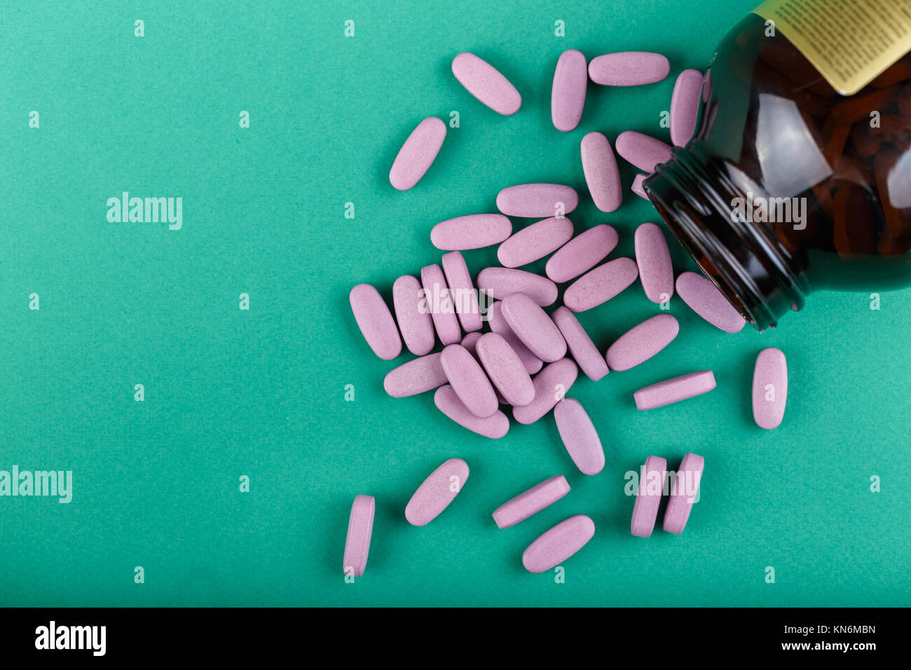 large pink tablets scattered on a green background. treatment of ...