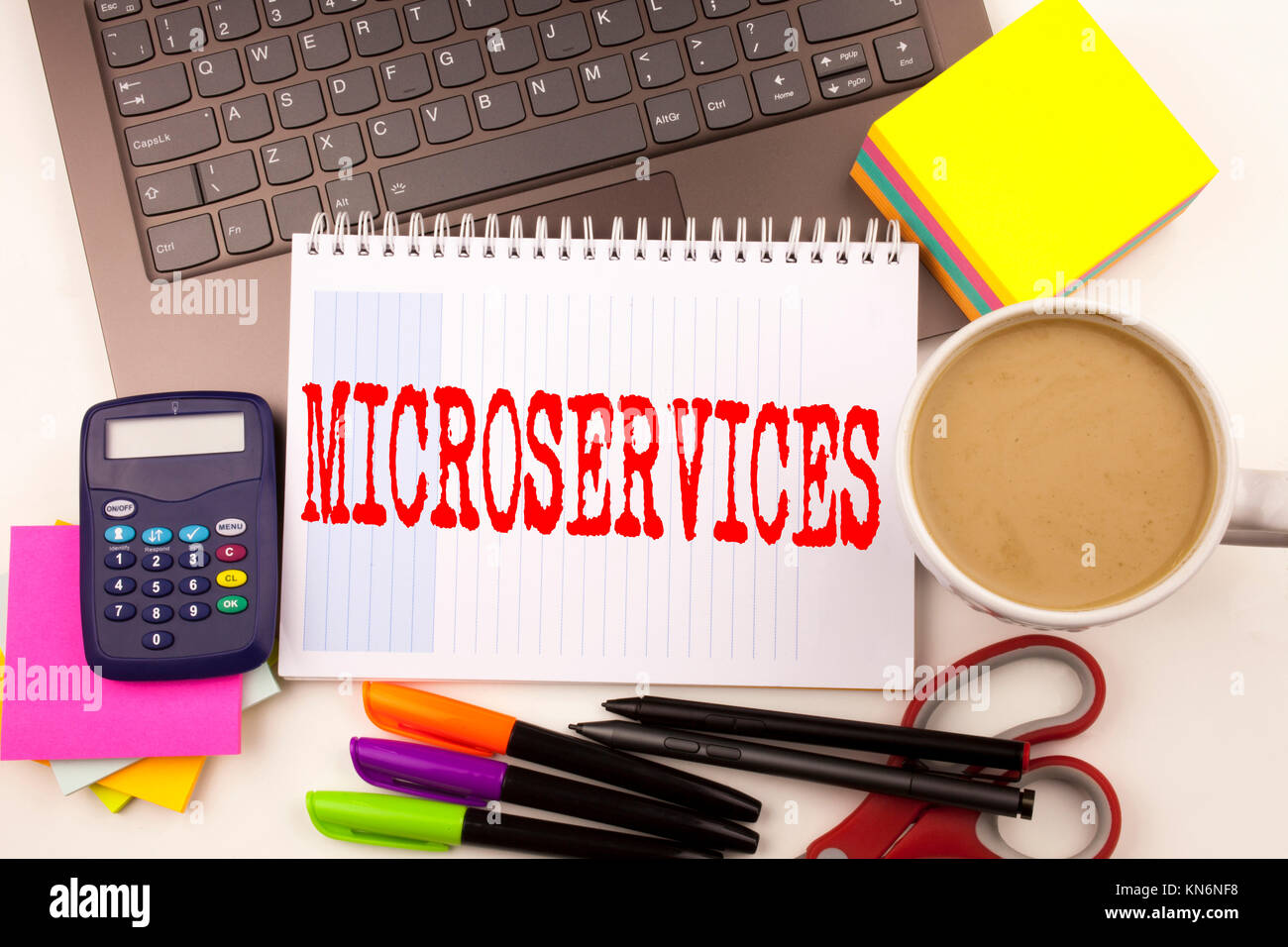 Word writing Microservices in the office with laptop, marker, pen ...