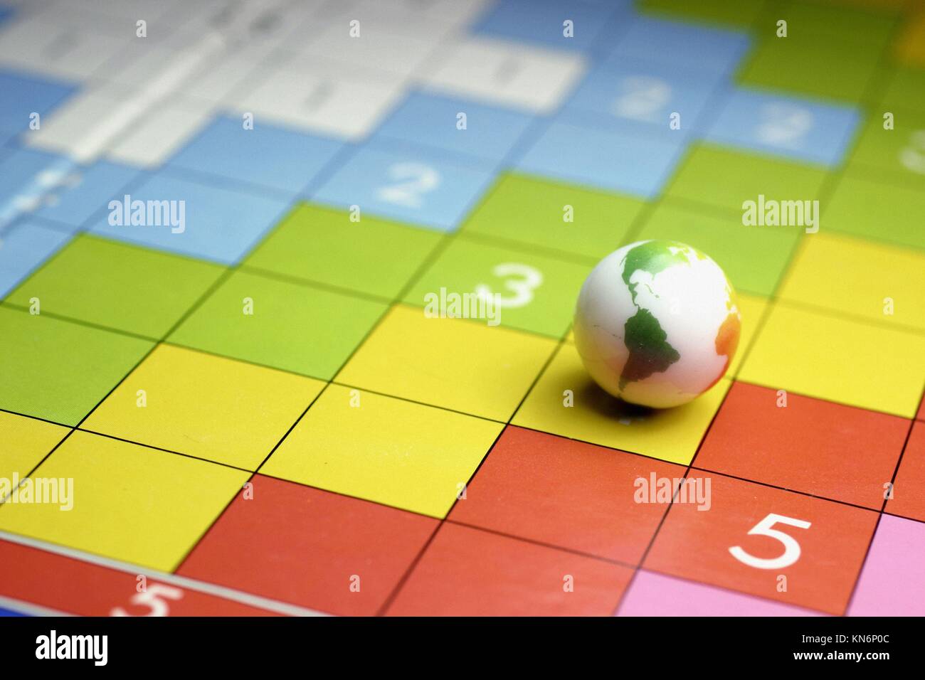 Marble globe on game board Stock Photo - Alamy