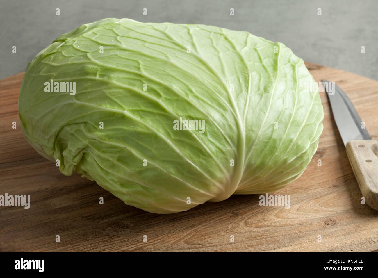 Whole flat coolwrap cabbage on a cutting board Stock Photo - Alamy