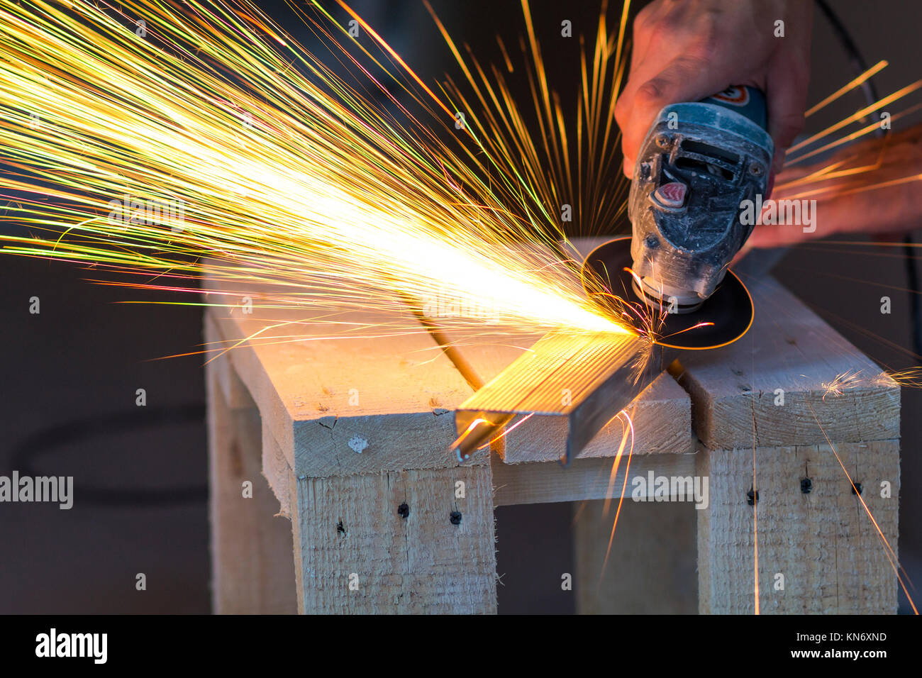 Close-up of worker hands cutting metal with grinder. Sparks while ...
