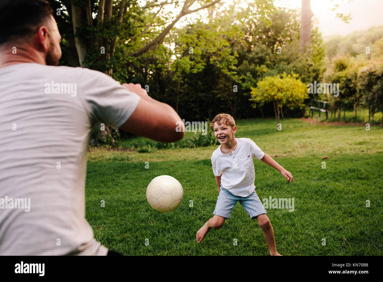 Father and son playing football in backyard garden. Happy little boy ...
