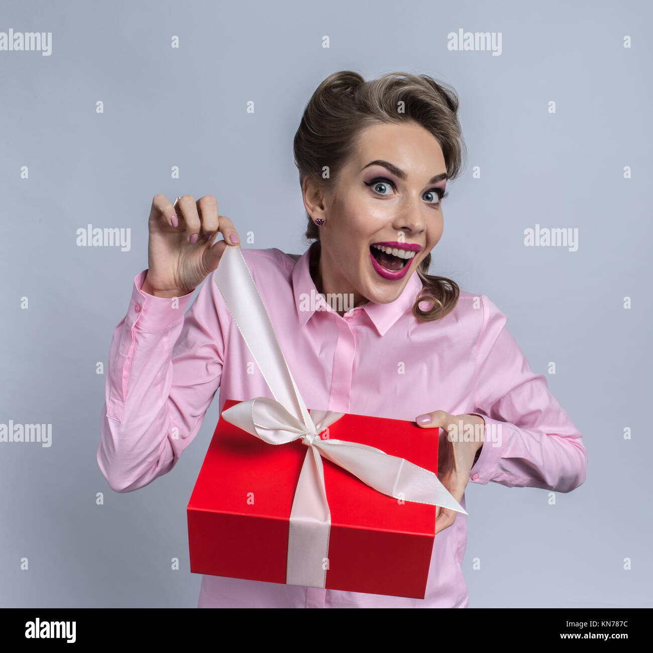 Happy beautiful funny woman unpacks gift Stock Photo - Alamy