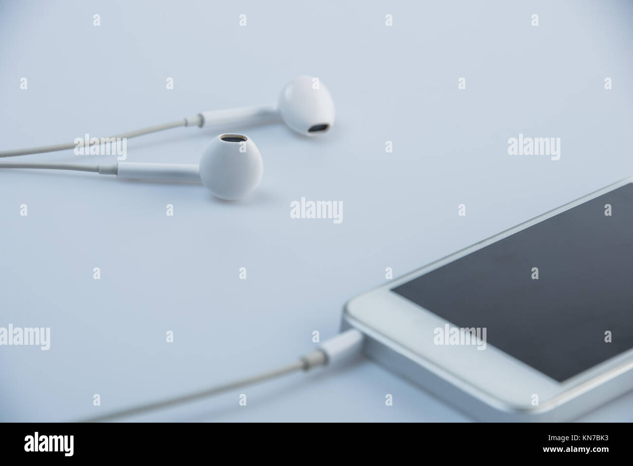 Smartphone and earbuds on table,white background Stock Photo - Alamy