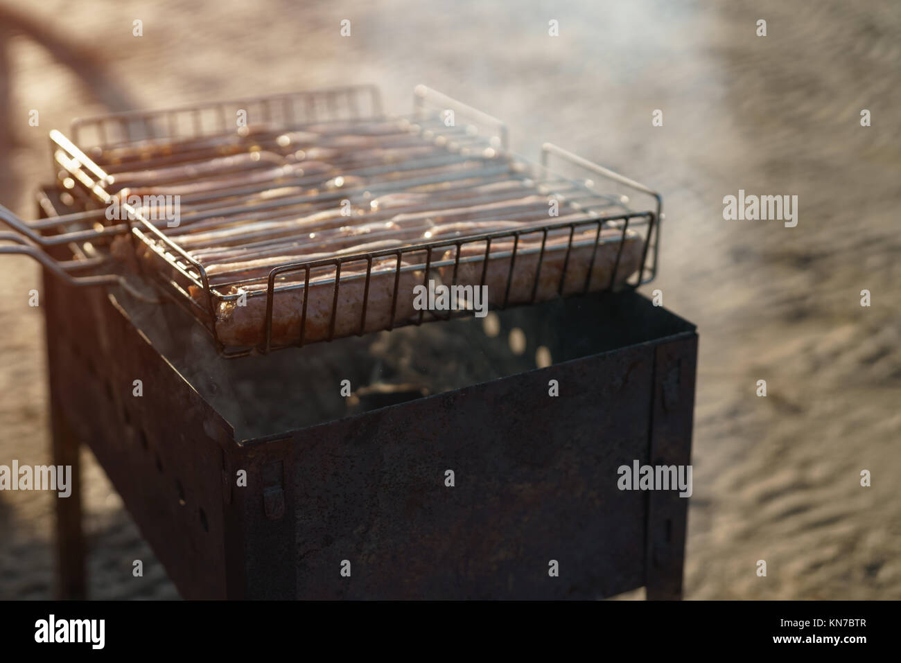 cooking bbq sausages on a beach, shallow focus Stock Photo - Alamy
