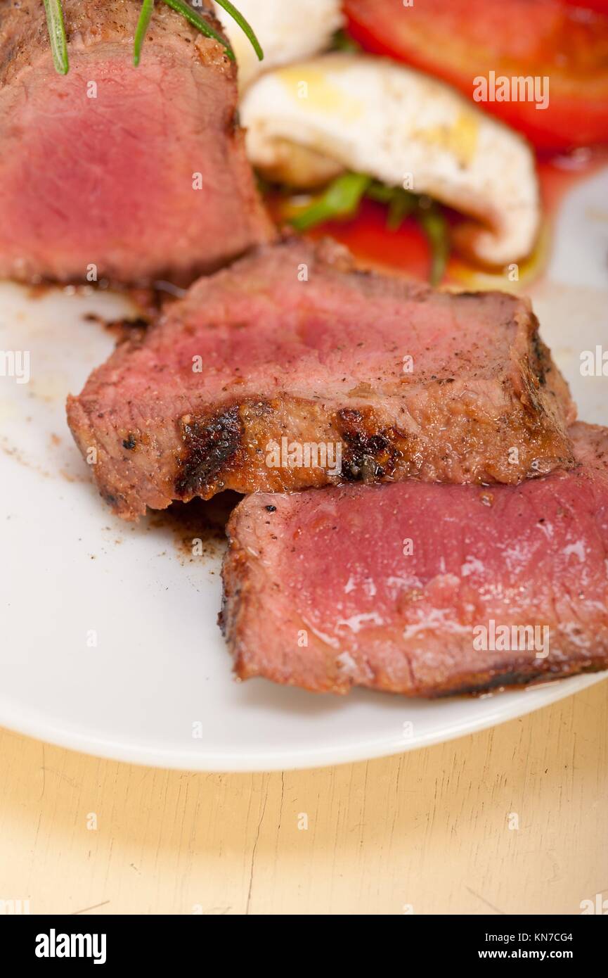 beef filet mignon grilled with fresh vegetables on side ,mushrooms tomato and arugula salad ...