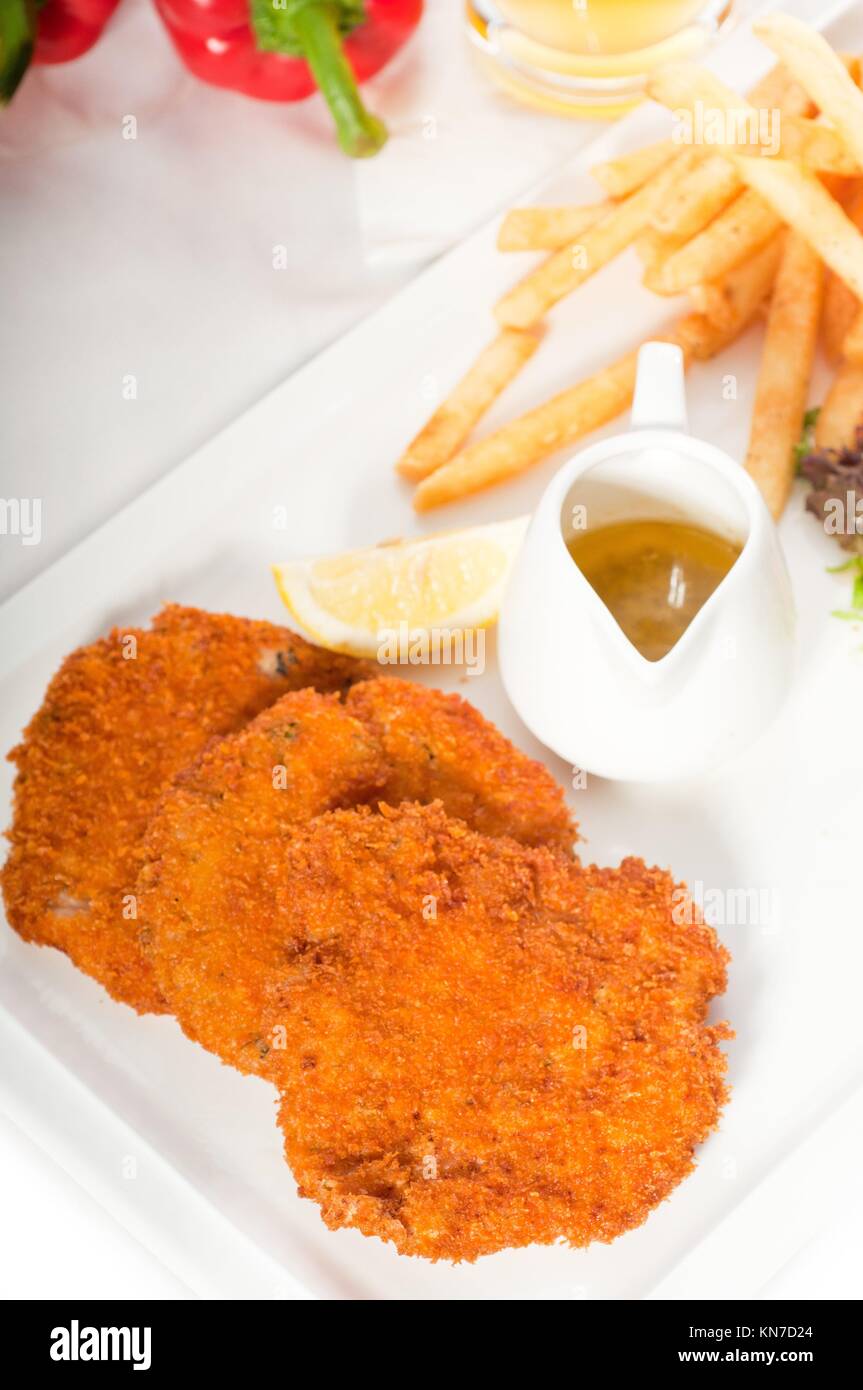 classic breaded Milanese veal cutlets with french fries and vegetables ...
