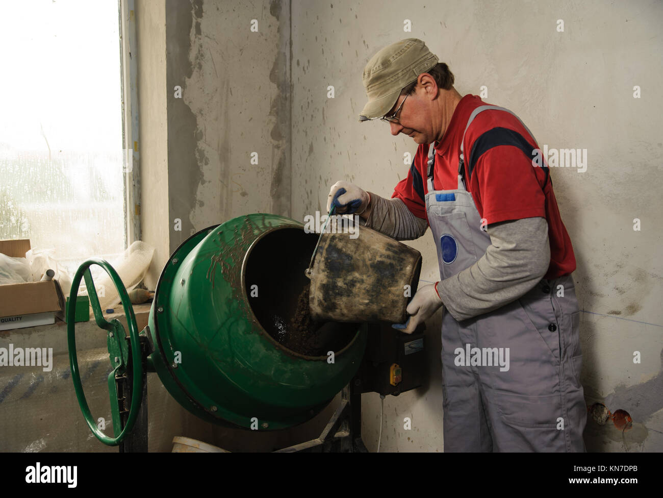 Concrete floor. Man worker fills mixer material for solution Stock ...