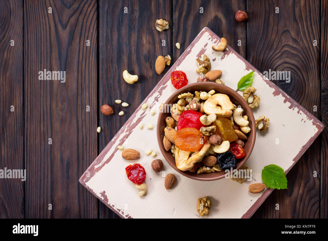 Mix of dried fruits and nuts on a wooden background. The concept of the ...