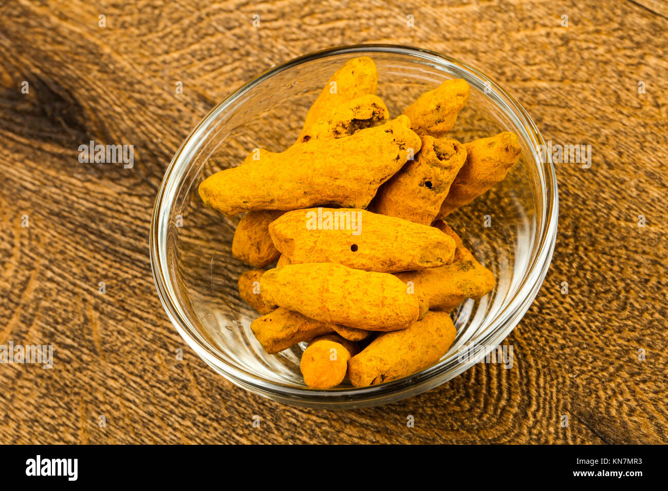 Tumeric roots heap in the bowl over wooden background Stock Photo - Alamy