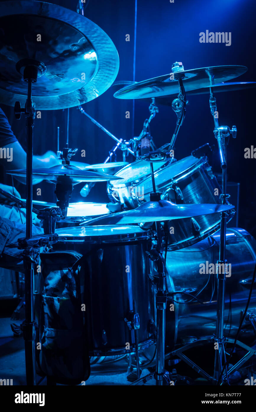 Drummer plays drums, side view, with blue concert lighting Stock Photo ...