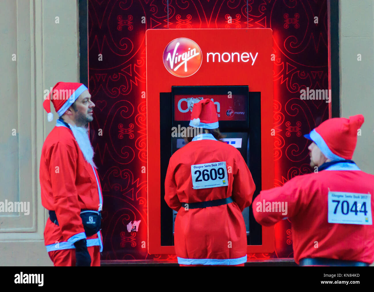 Glasgow, Scotland, UK. 10th December, 2017: Santas withdrawing cash at ...