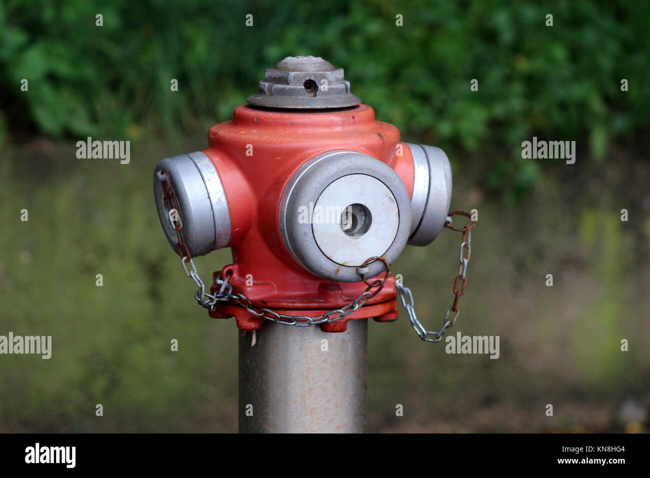 Metal red and grey fire hydrant top with four caps connected with small ...