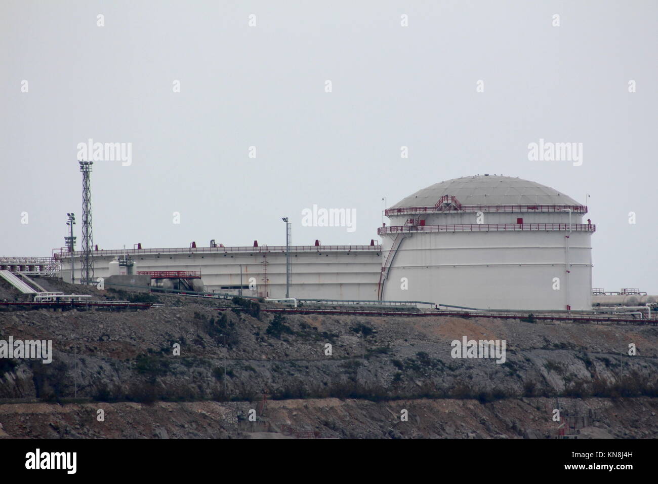 Large industrial oil refinery tank connected to massive storage unit ...