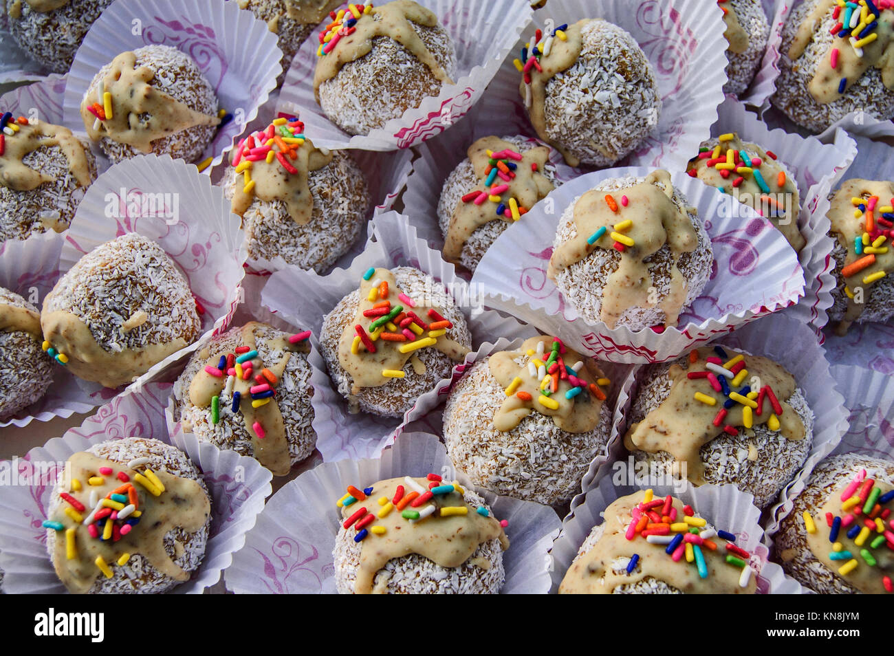 Small sweet round cakes coated with chocolate and coconut flour and ...