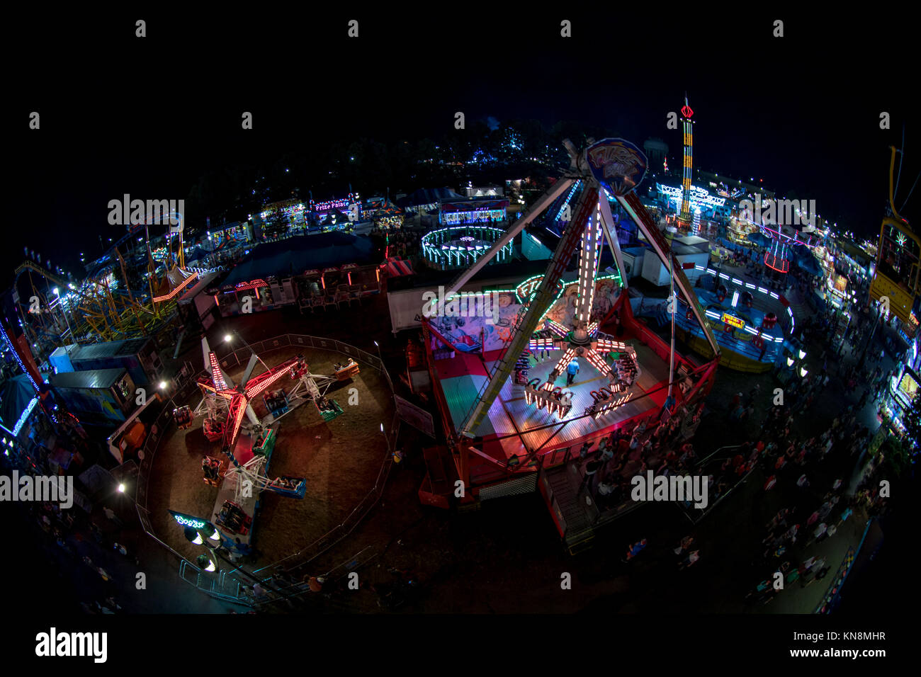Neon lights of carnival rides light up midway at night Stock Photo - Alamy
