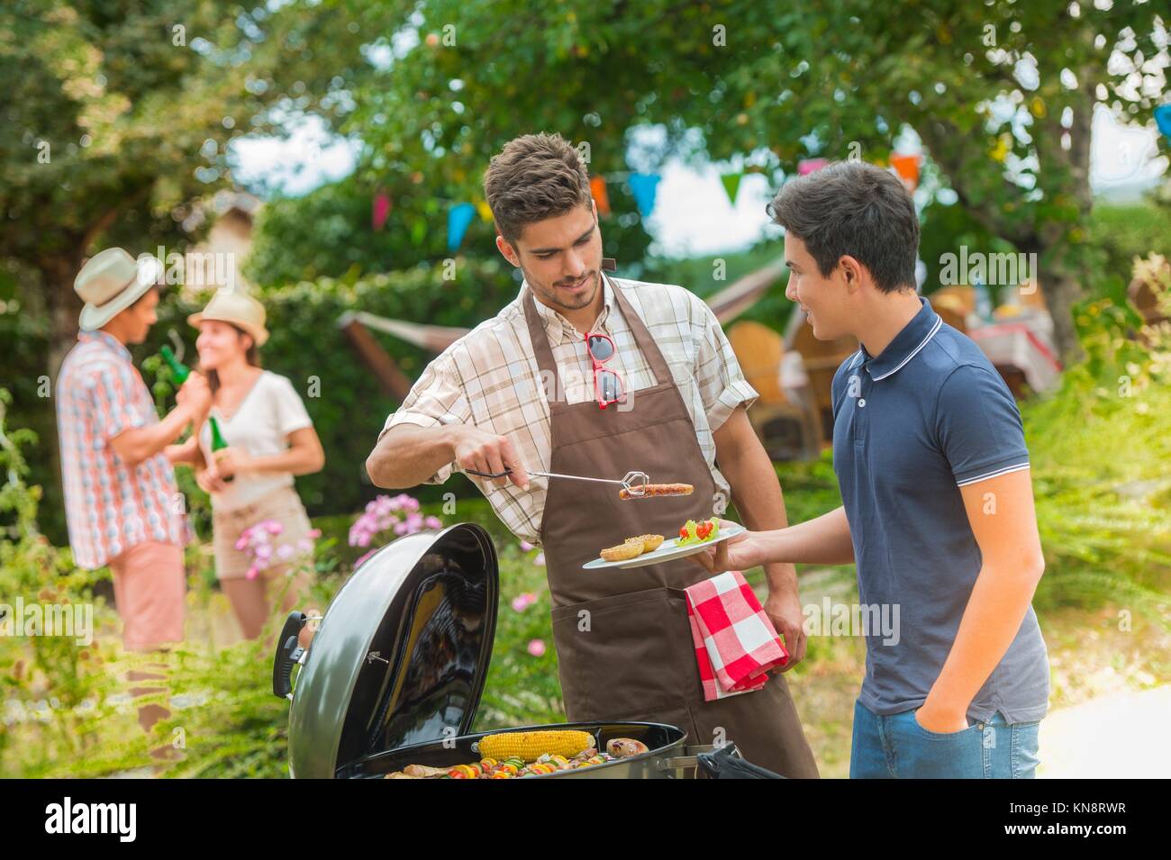 Happy family having barbecue garden hi-res stock photography and images ...