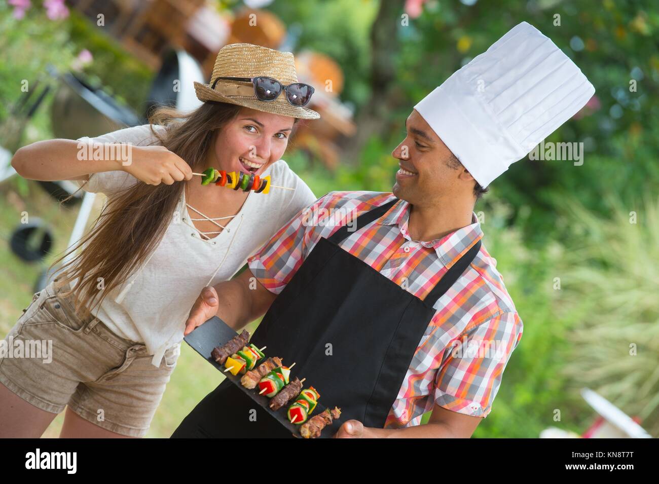 Happy couple cooking meat on barbecue grill, France Stock Photo - Alamy