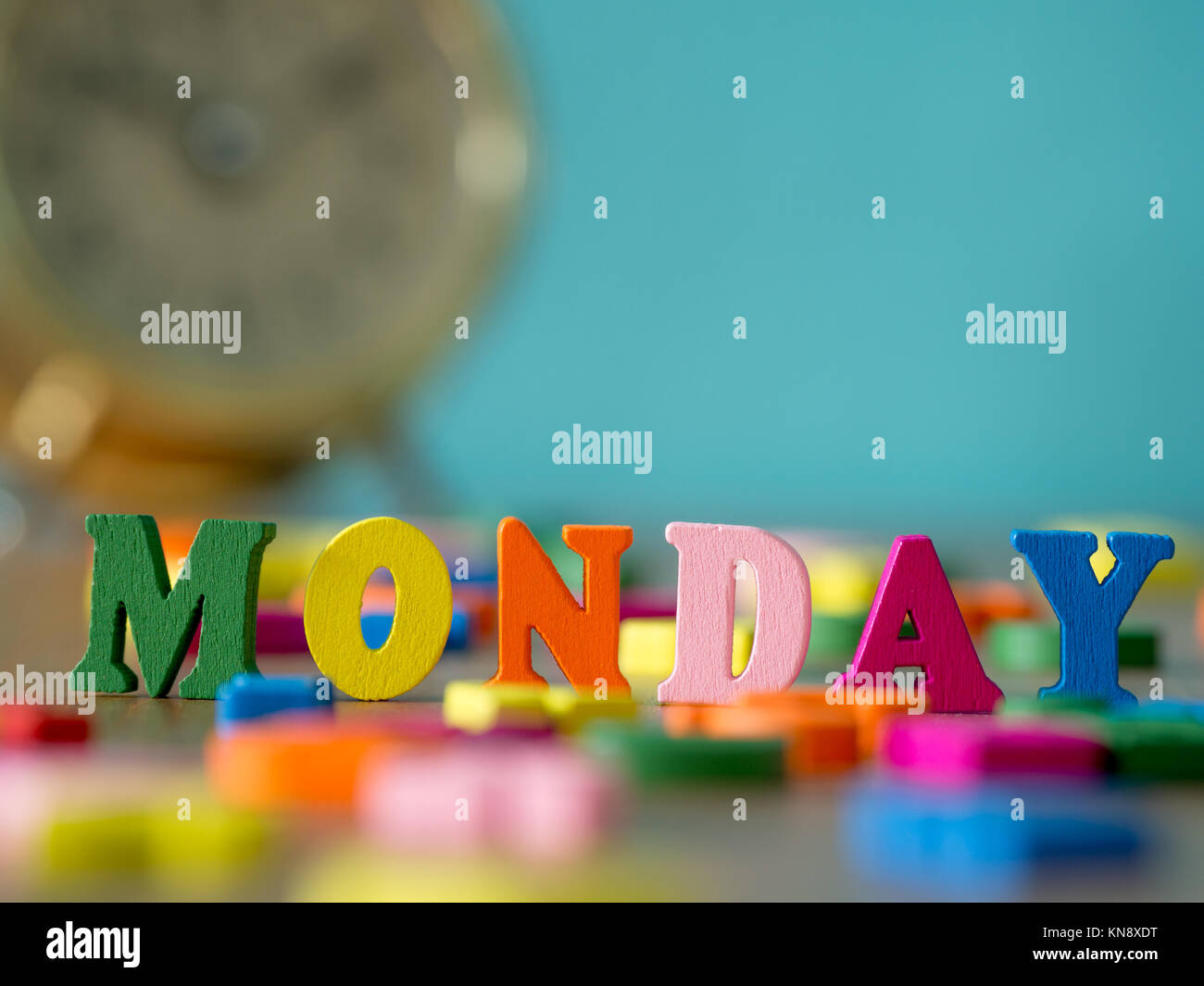 Colorful wooden word MONDAY on wooden table and vintage alarm clock and ...