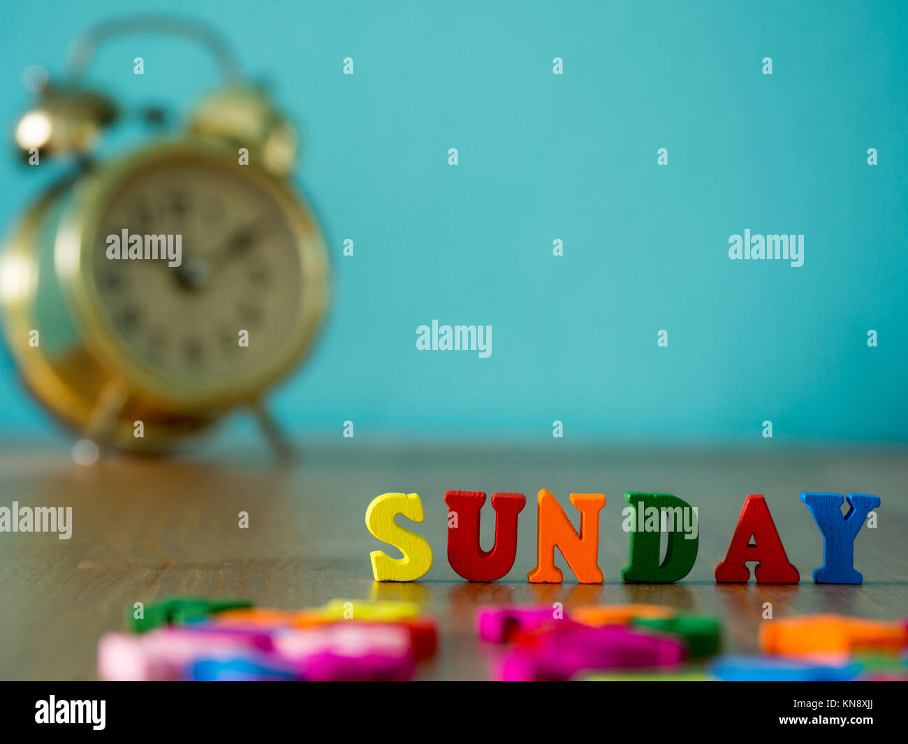 Colorful wooden word SUNDAY on wooden table and vintage alarm clock and ...