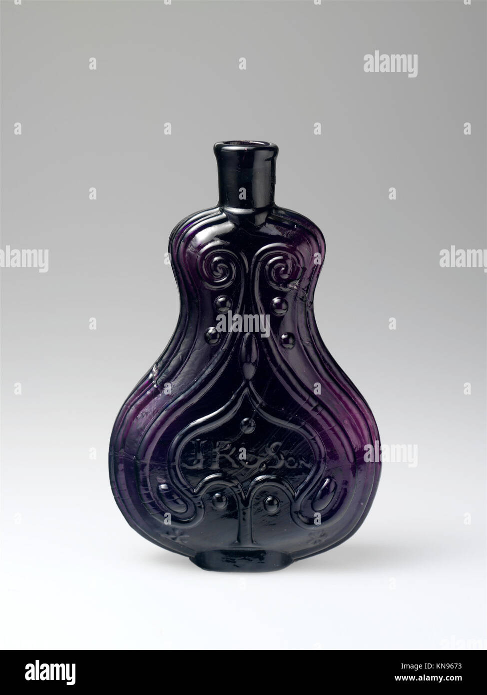 This figured flask features intricate design elements, combining both ...