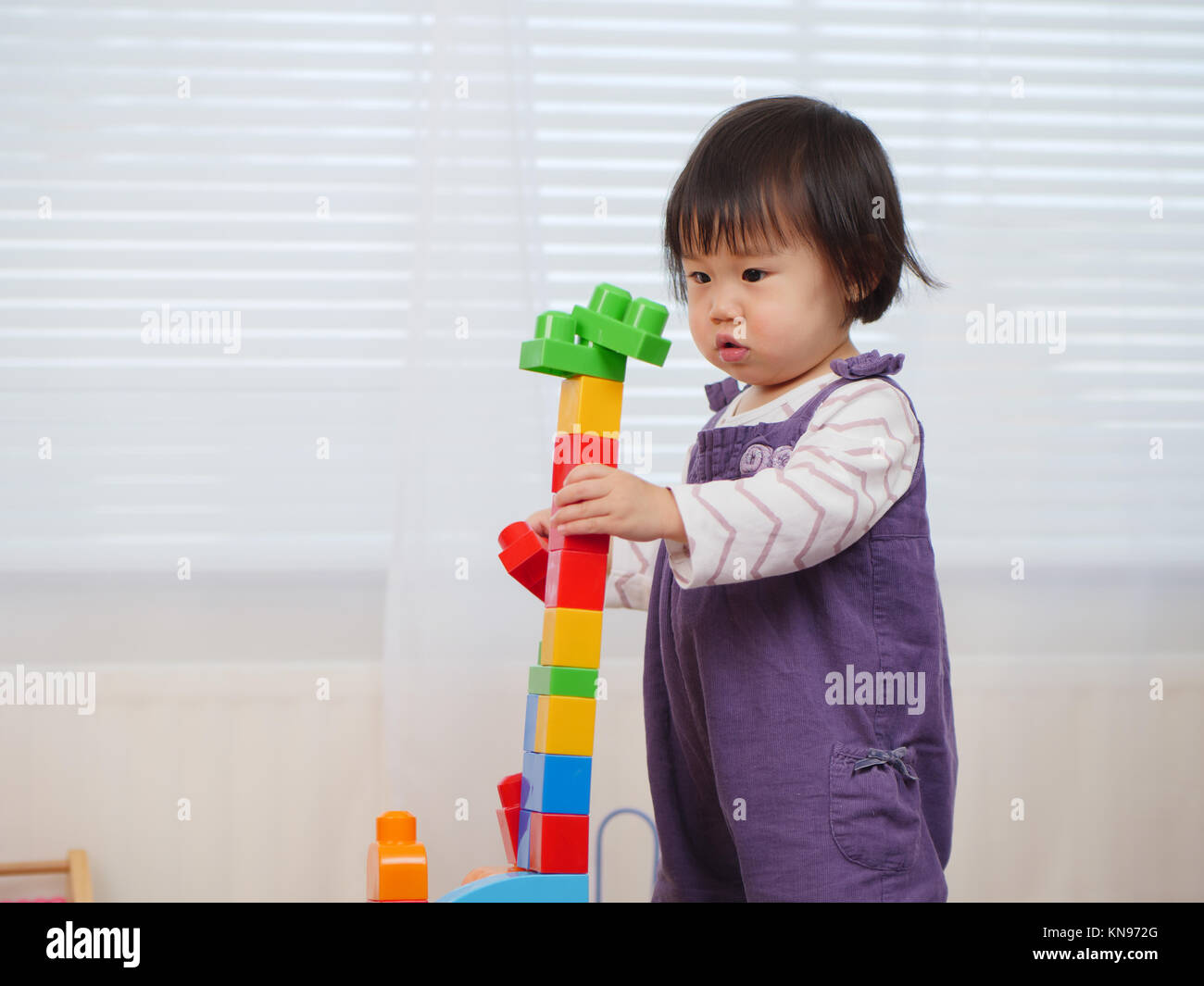 Baby girl play building blocks at home Stock Photo - Alamy