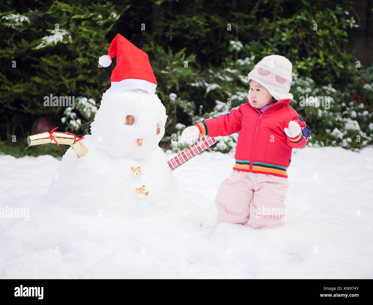 Baby girl play with Christmas snowman Stock Photo - Alamy